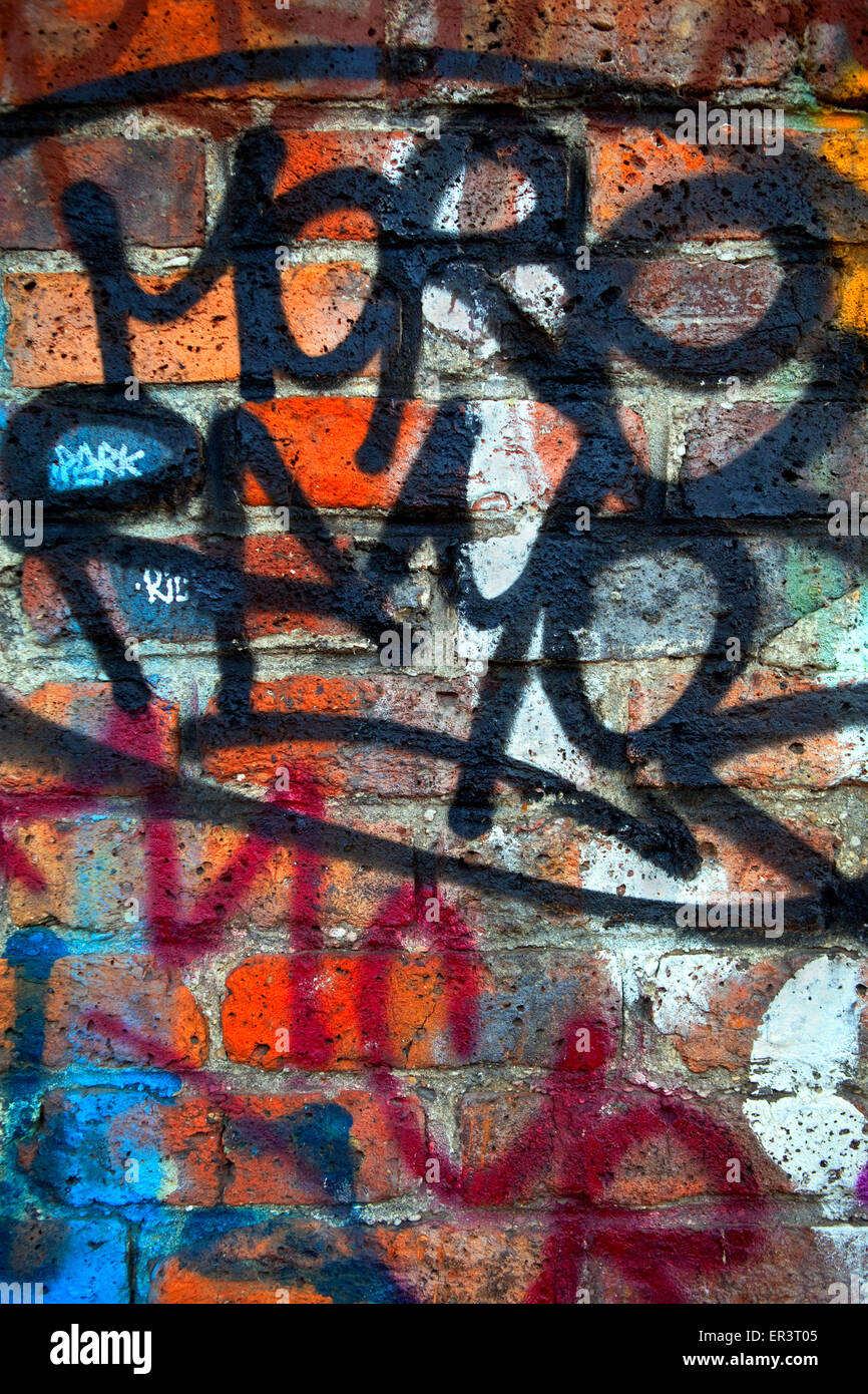 Graffiti and tags on a colorful brick wall Stock Photo - Alamy