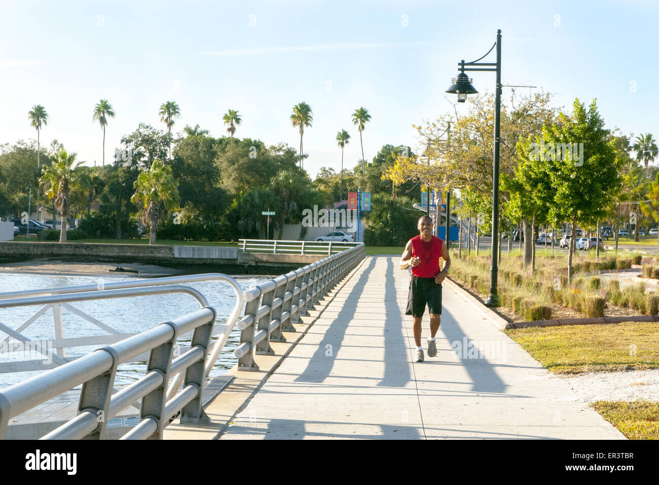 Man jogging along the river walk practicing social distancing Stock ...