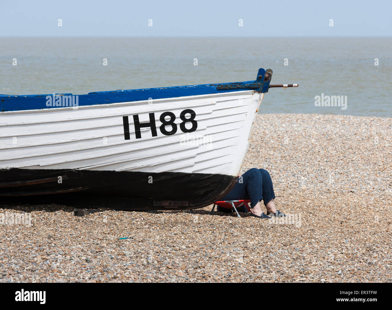 legs poking out from behind fishing boat Stock Photo - Alamy