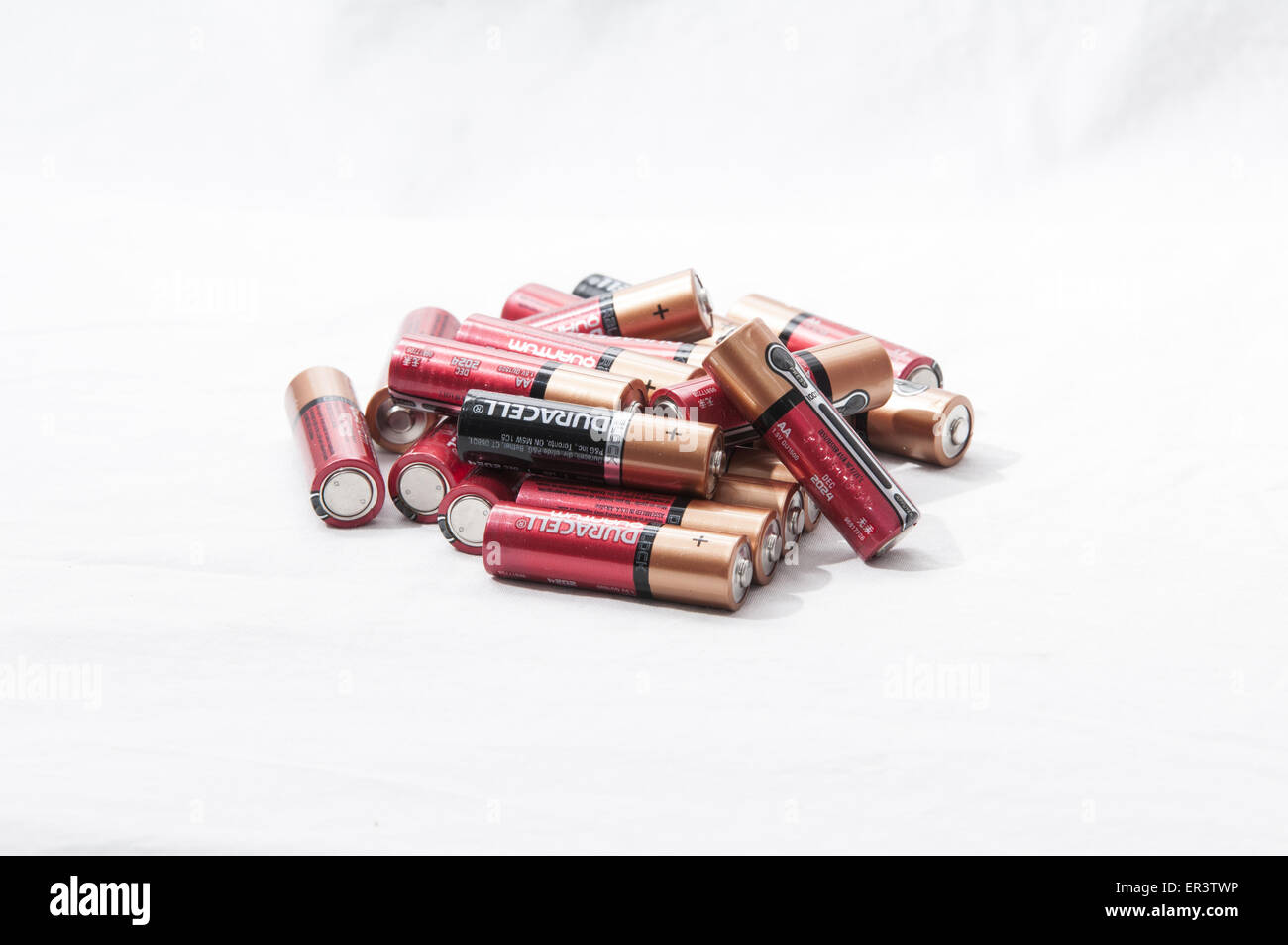 Still life image of a pile of Duracell AA batteries on a white ...