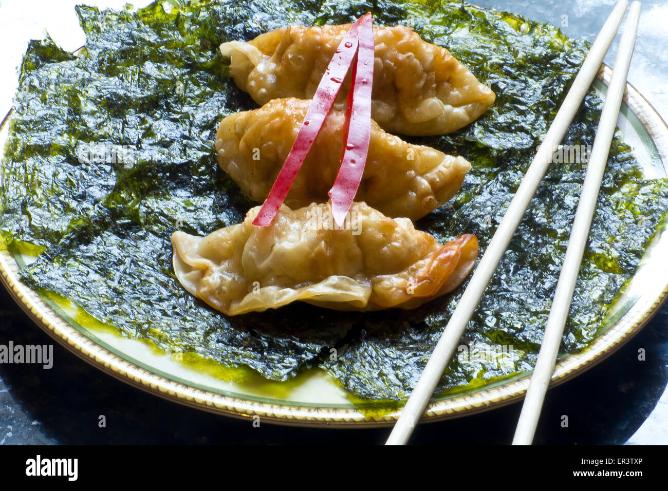 Fried Japanese dumplings on crispy roasted seaweed and red pepper ...