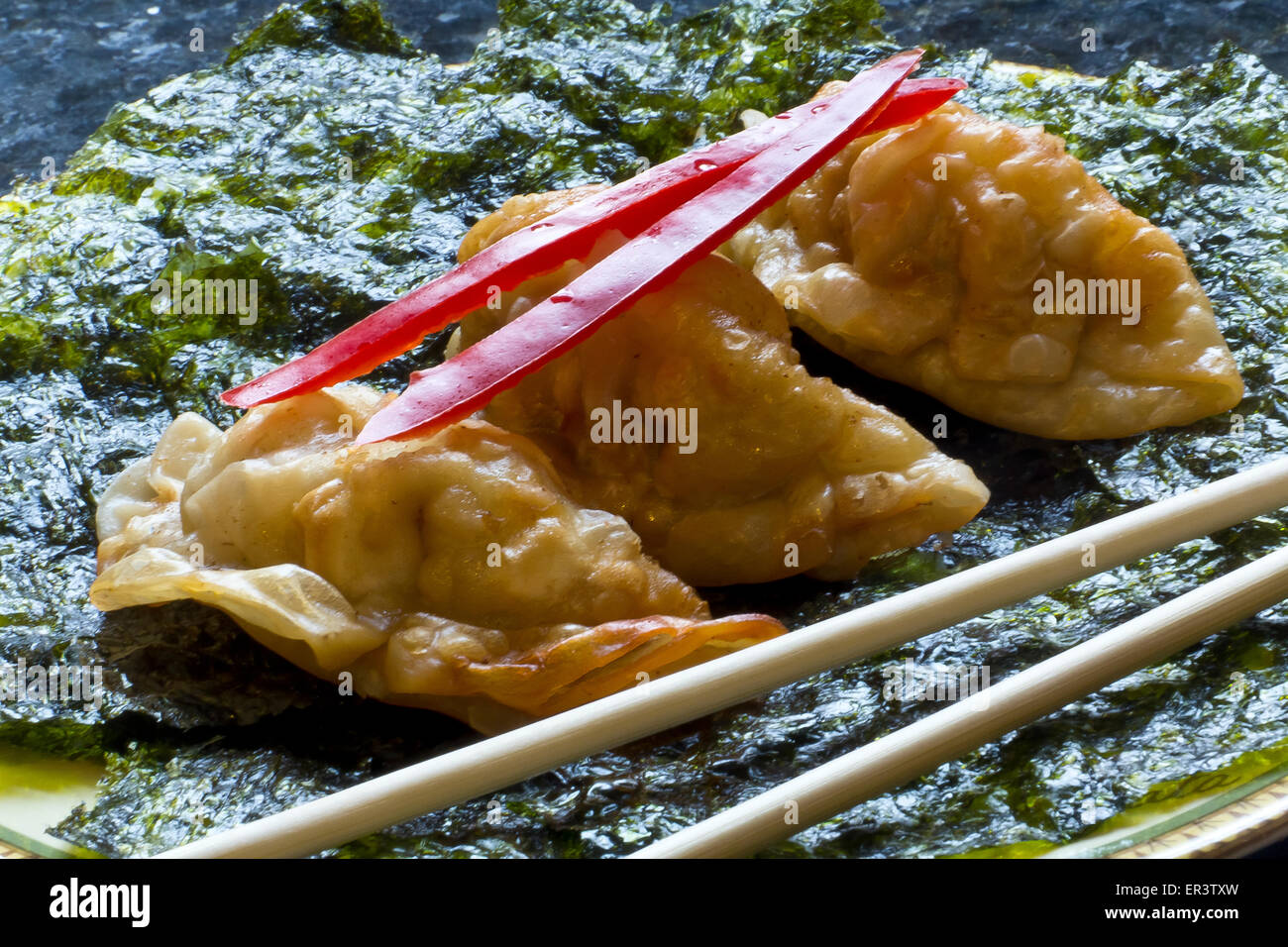 Fried Japanese dumplings on crispy roasted seaweed and red pepper ...