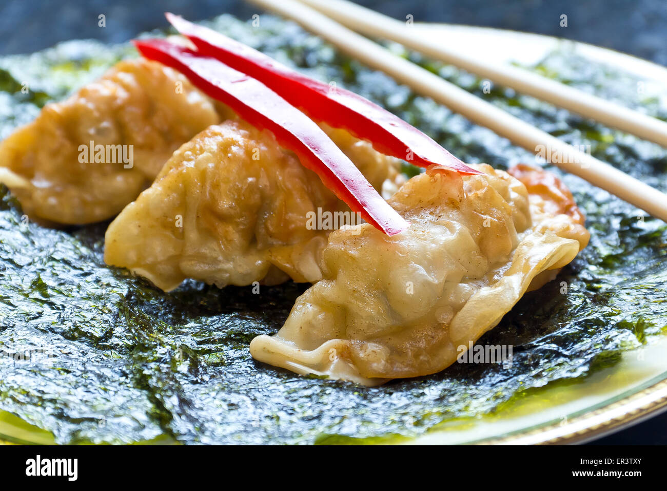Fried Japanese dumplings on crispy roasted seaweed and red pepper ...