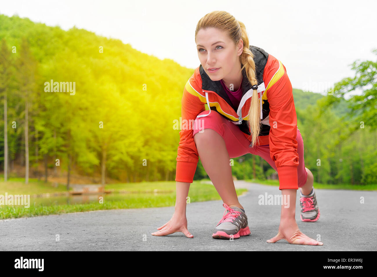 Attractive blonde woman running on track outdoors Stock Photo - Alamy