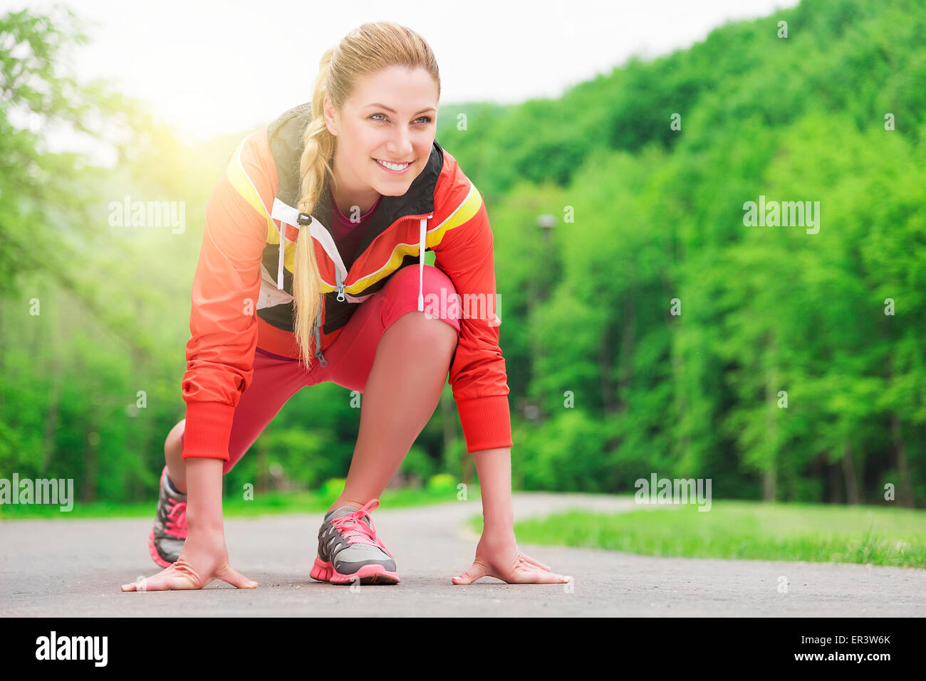 Attractive blonde woman running on track outdoors Stock Photo - Alamy