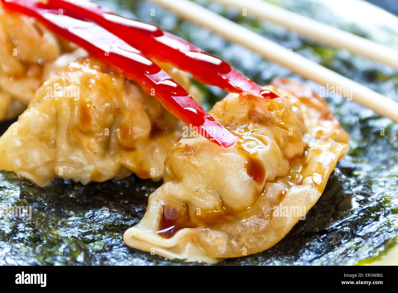 Fried Japanese dumplings on crispy roasted seaweed and red pepper ...