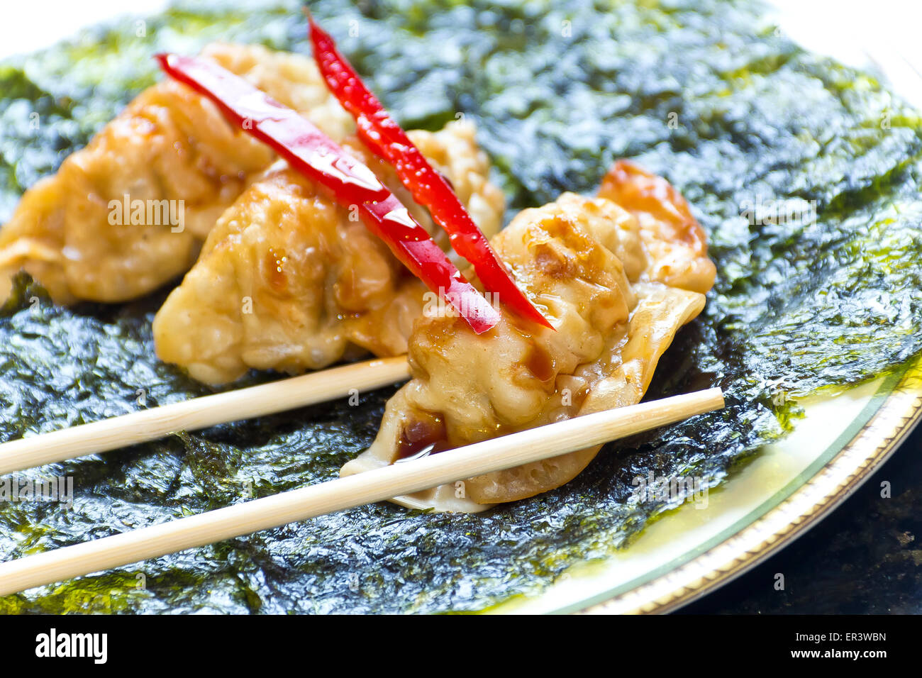 Fried Japanese dumplings on crispy roasted seaweed and red pepper ...