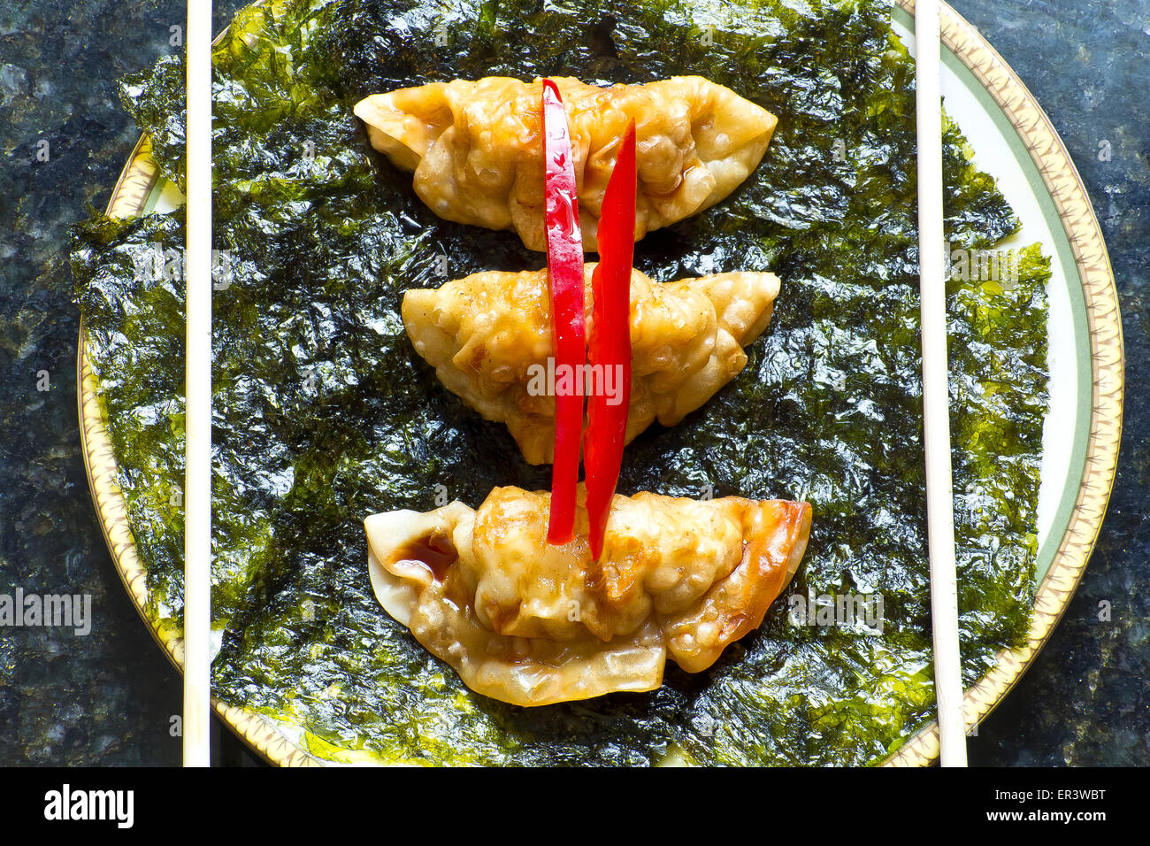 Fried Japanese dumplings on crispy roasted seaweed and red pepper ...