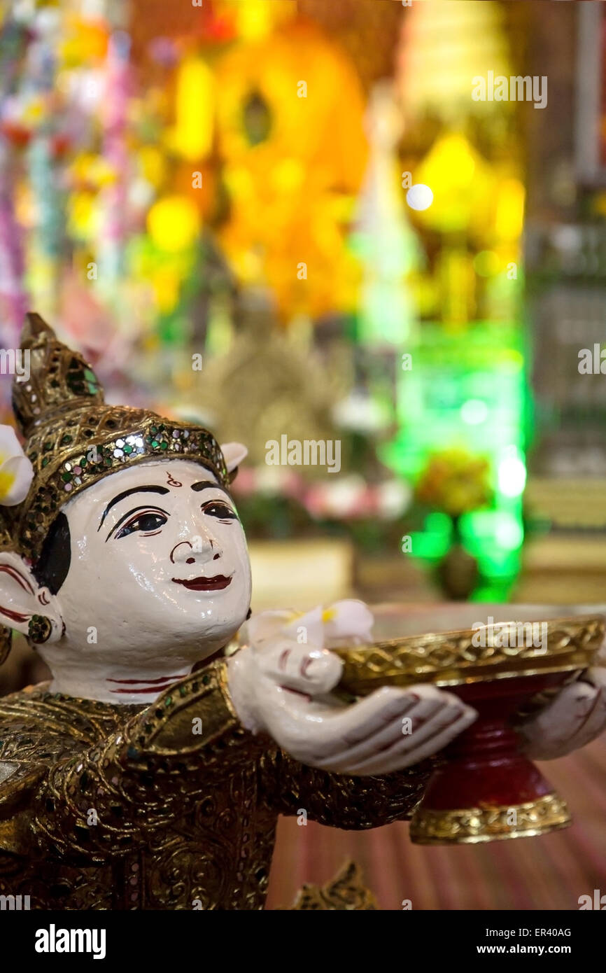 Buddhist angel holding a bowl of coins Stock Photo - Alamy
