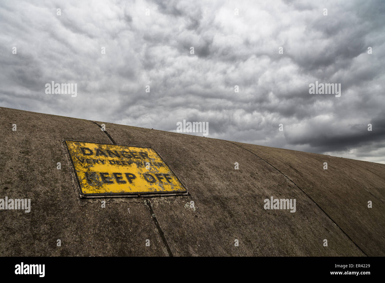 A warning sign under a cloudy sky Stock Photo - Alamy