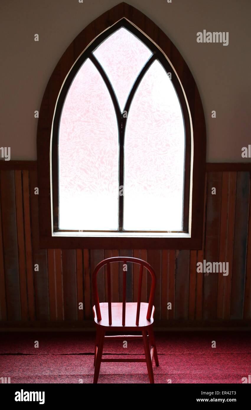 An empty chair facing a church window Stock Photo - Alamy