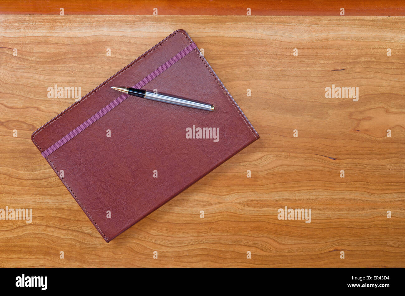 Executive notepad with pen on cherry wood desktop with plenty of copy ...