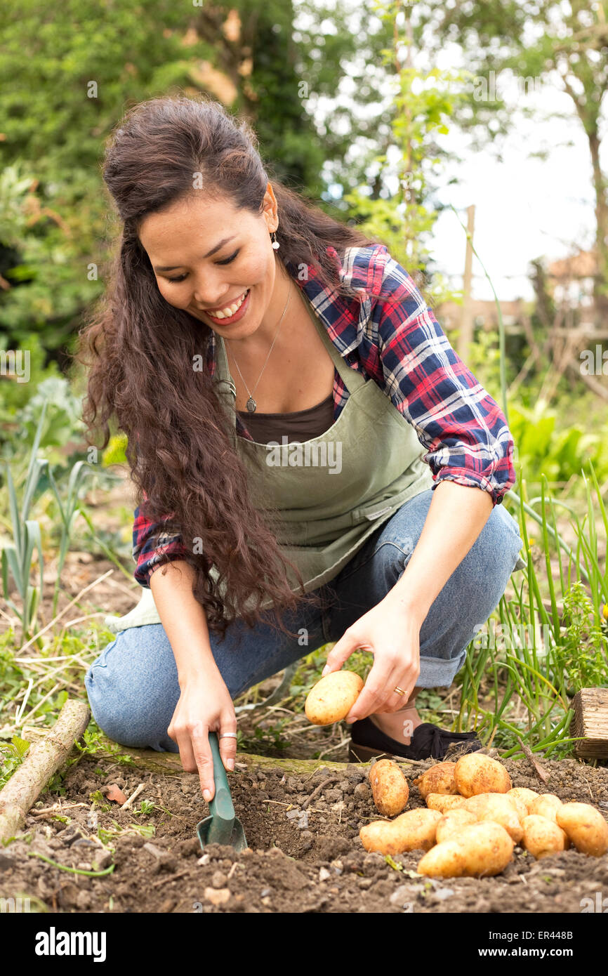 young woman sowing potatoes Stock Photo - Alamy