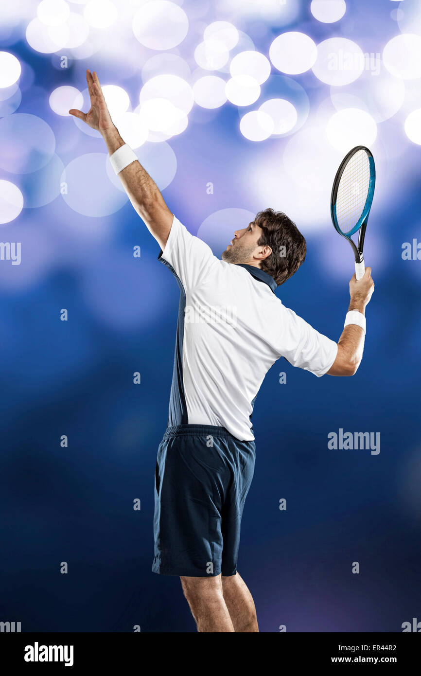 Tennis player playing on blue lights background Stock Photo - Alamy