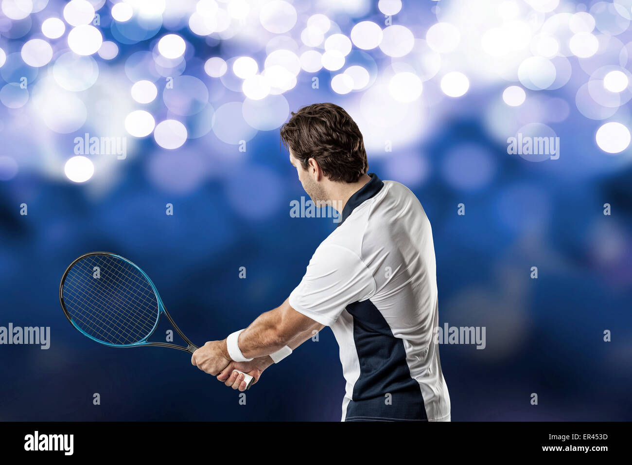 Tennis player playing on blue lights background Stock Photo - Alamy