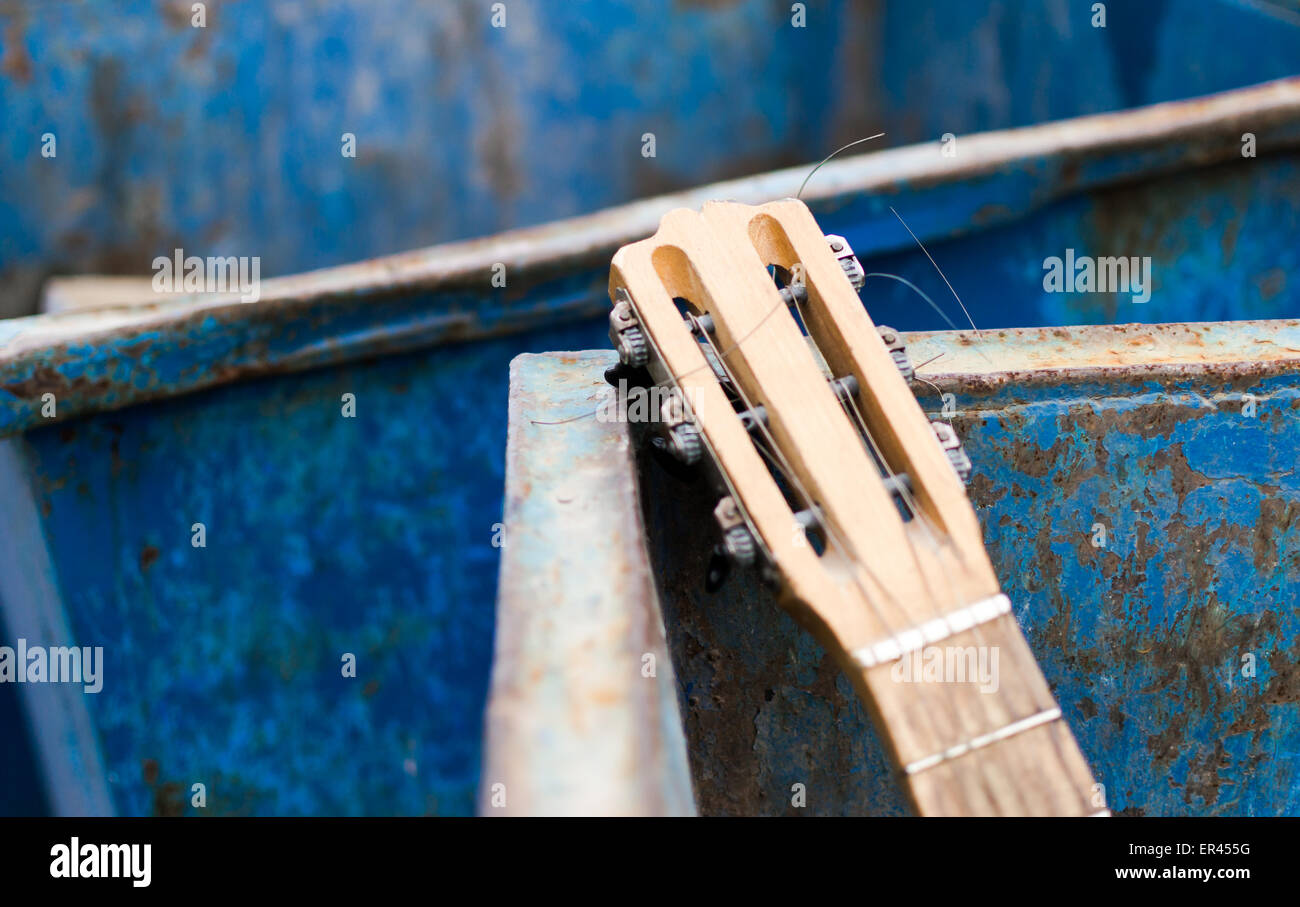 Old unwanted guitar thrown away in an rusty metal dumpster Stock Photo ...