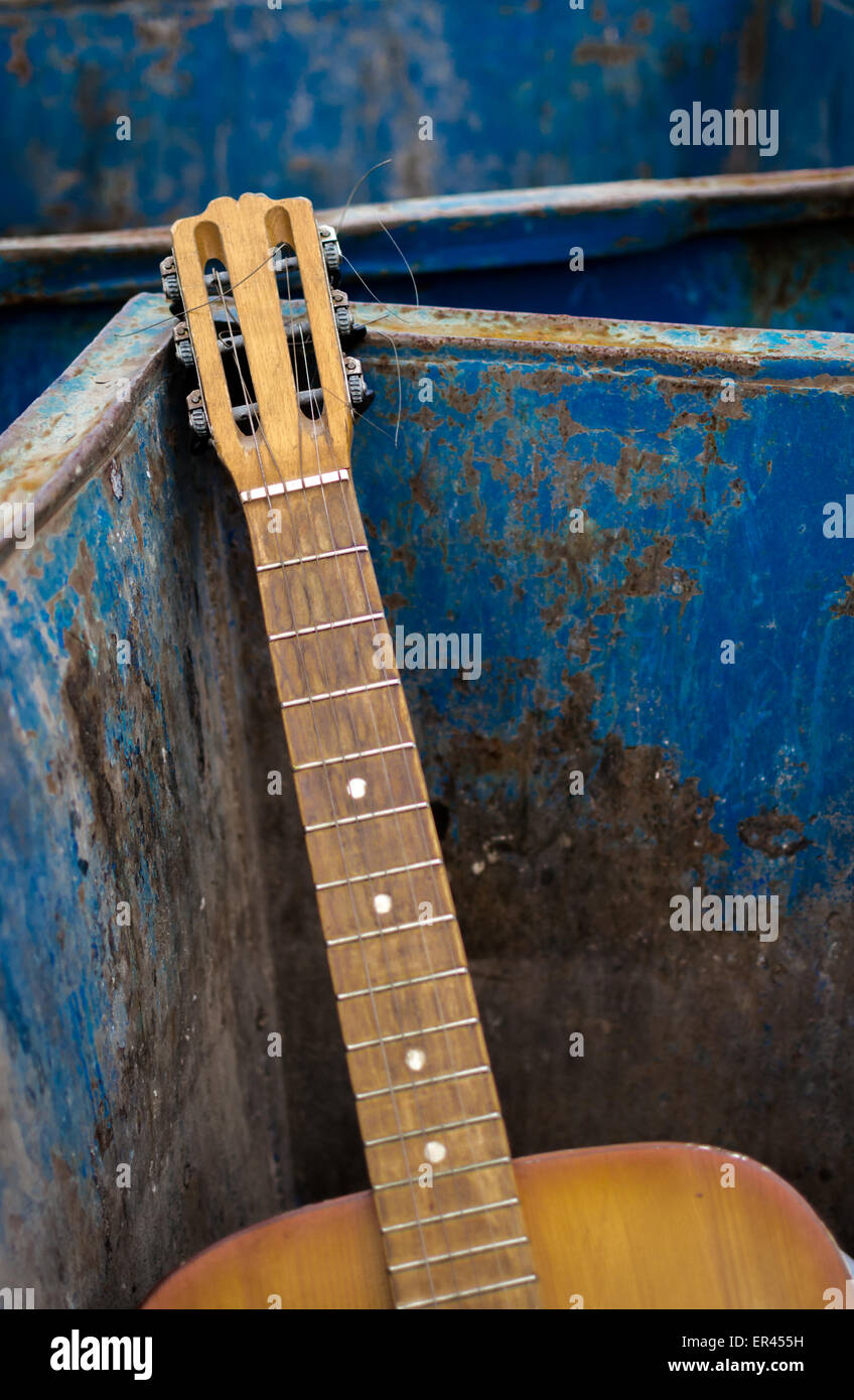 Old unwanted guitar thrown away in an rusty metal dumpster Stock Photo ...