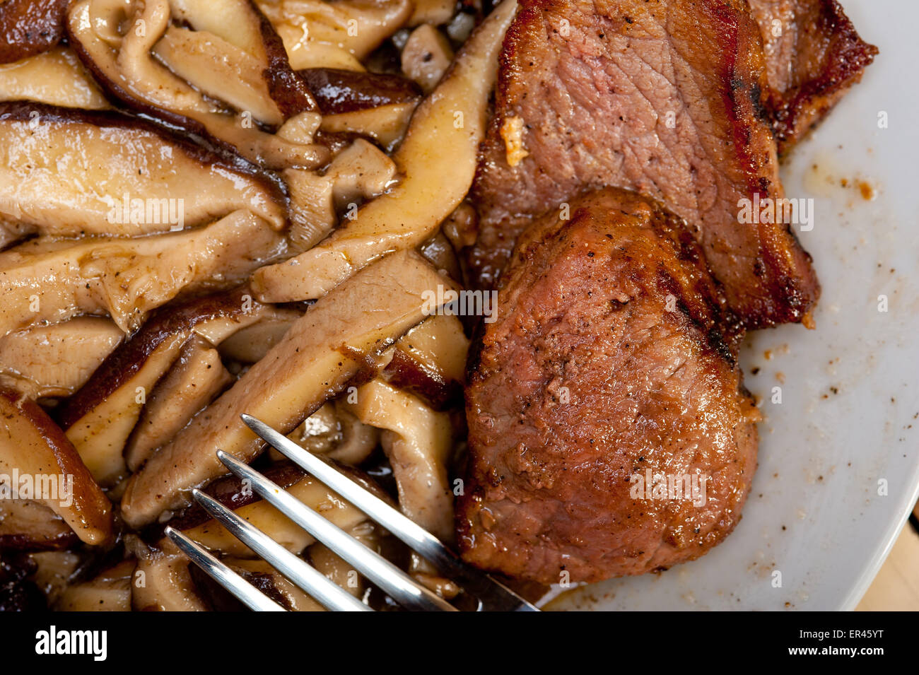 venison deer game filet tenderloin and fresh wild mushrooms Stock Photo ...
