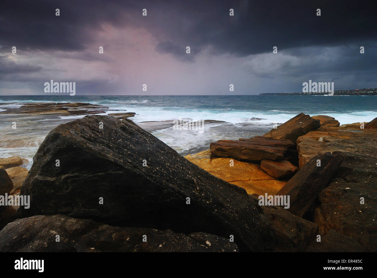 Rocky seascape sunrise scene with distant ocean and colored rocks on ...