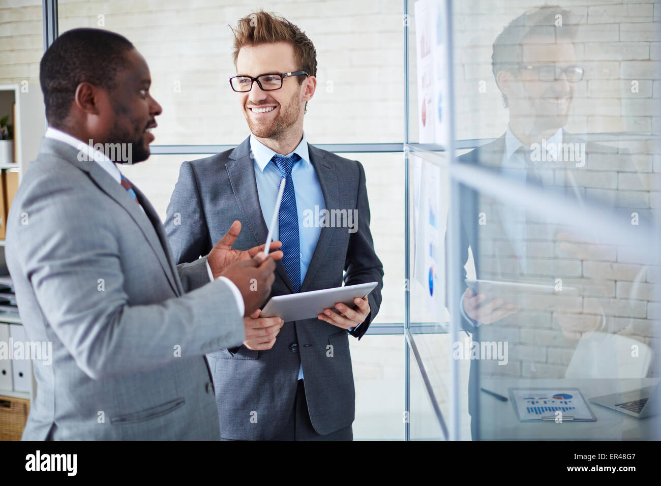 Two confident colleagues sharing ideas at meeting in office Stock Photo ...