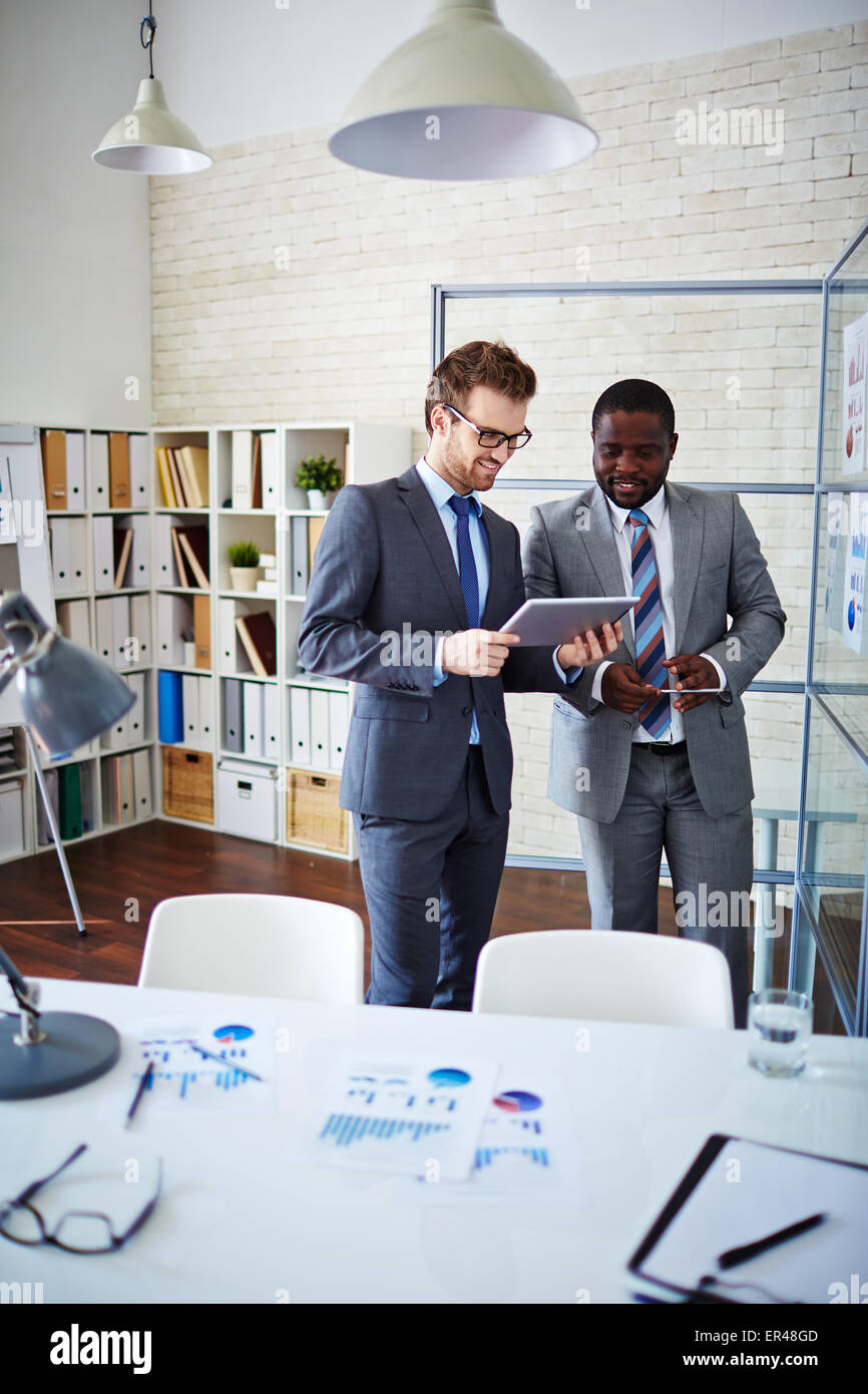 Confident managers looking at data while discussing new ideas Stock ...