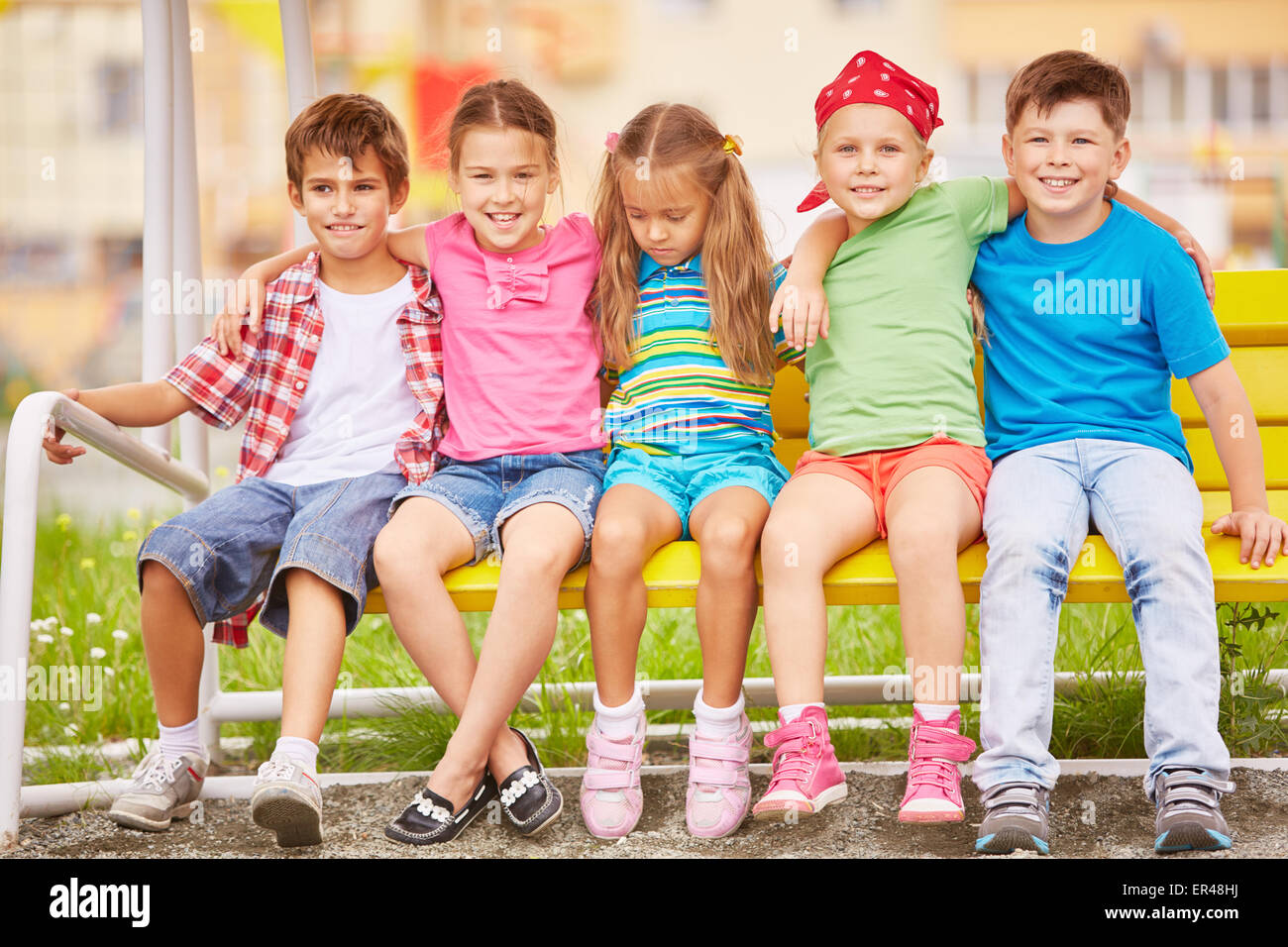 Group of friendly kids sitting on bench outside Stock Photo - Alamy