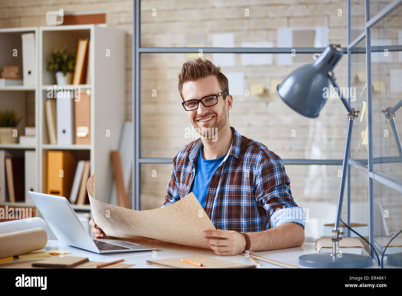 Handsome architect with blueprint looking at camera Stock Photo - Alamy