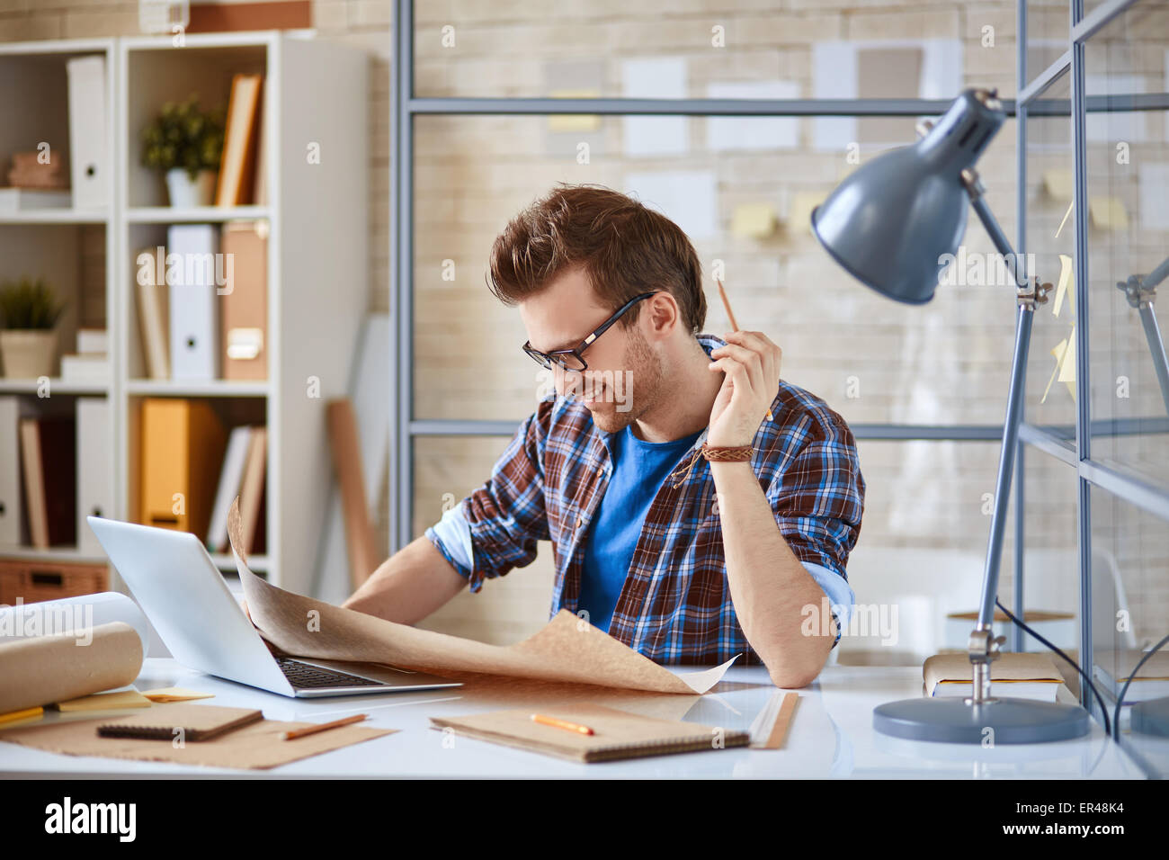 Young businessman learning draft at workplace Stock Photo - Alamy