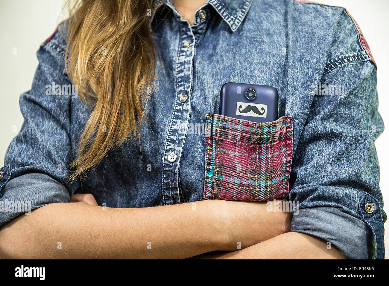 Teenager girl with a phone in her pocket with her hands crossed and ...