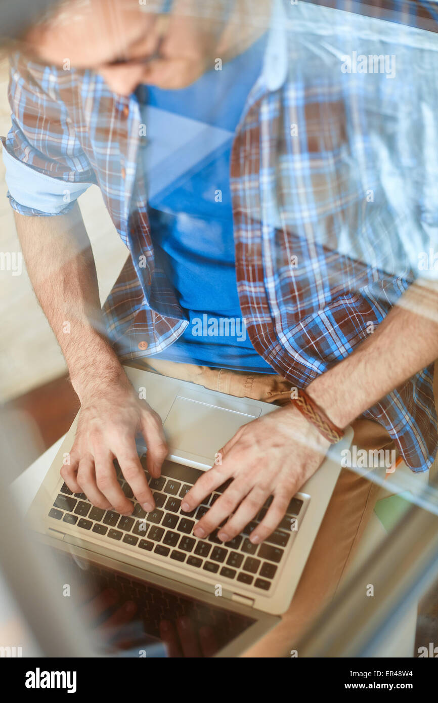 Young businessman typing on laptop keypad Stock Photo - Alamy