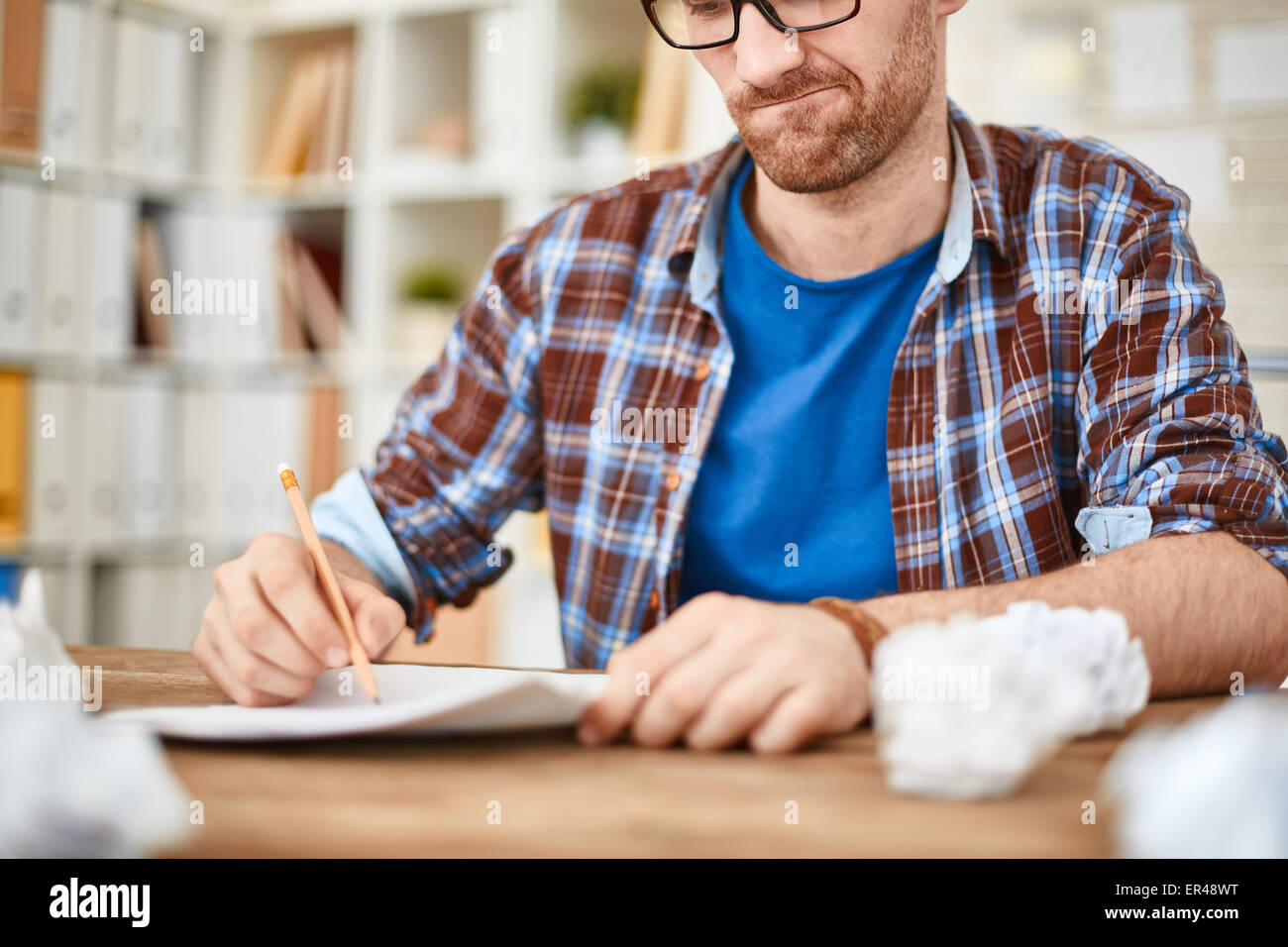 Young businessman with pencil writing down his ideas with crumpled ...