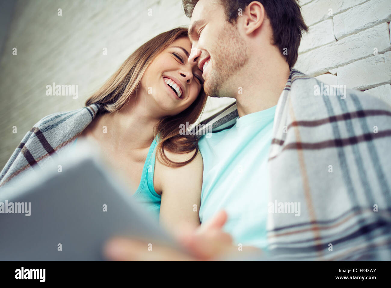 Happy girl laughing while cuddling to guy Stock Photo - Alamy