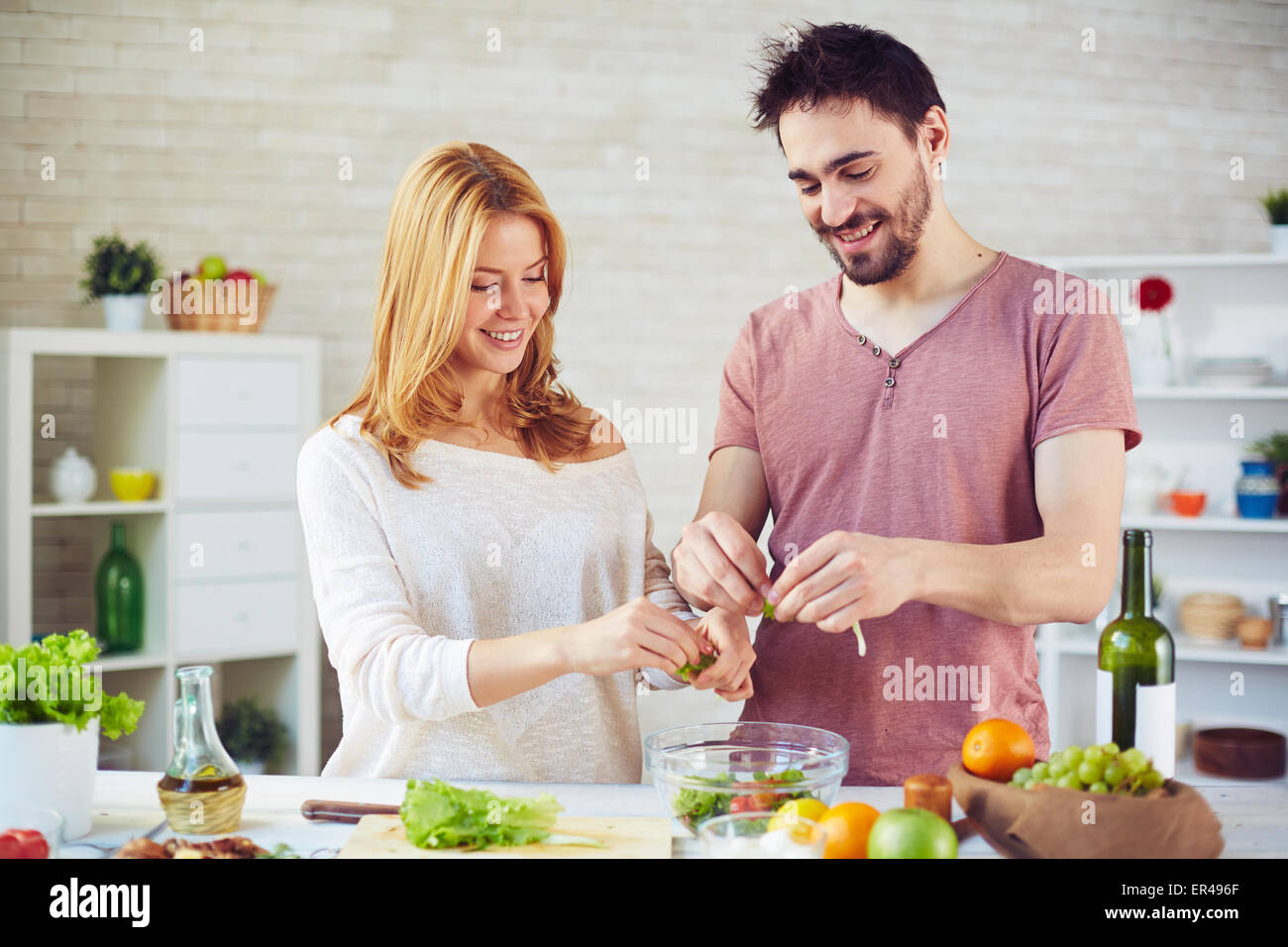 Amorous young couple cooking salad together Stock Photo - Alamy