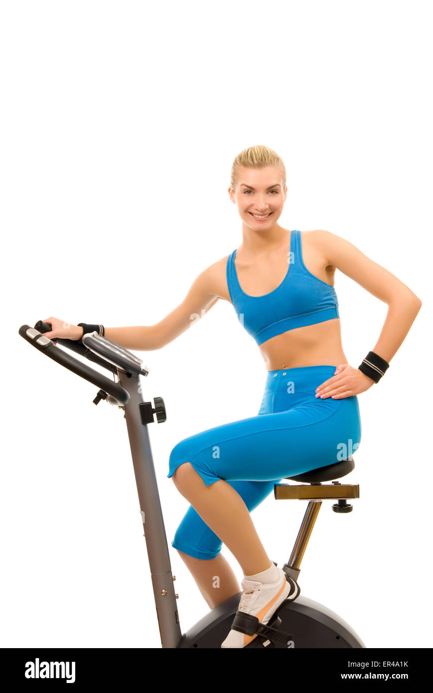 Beautiful young woman on exercise bicycle over white background Stock ...