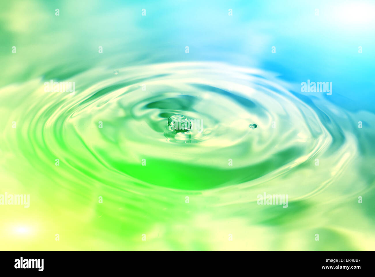 Water drop falling in colorful water Stock Photo - Alamy