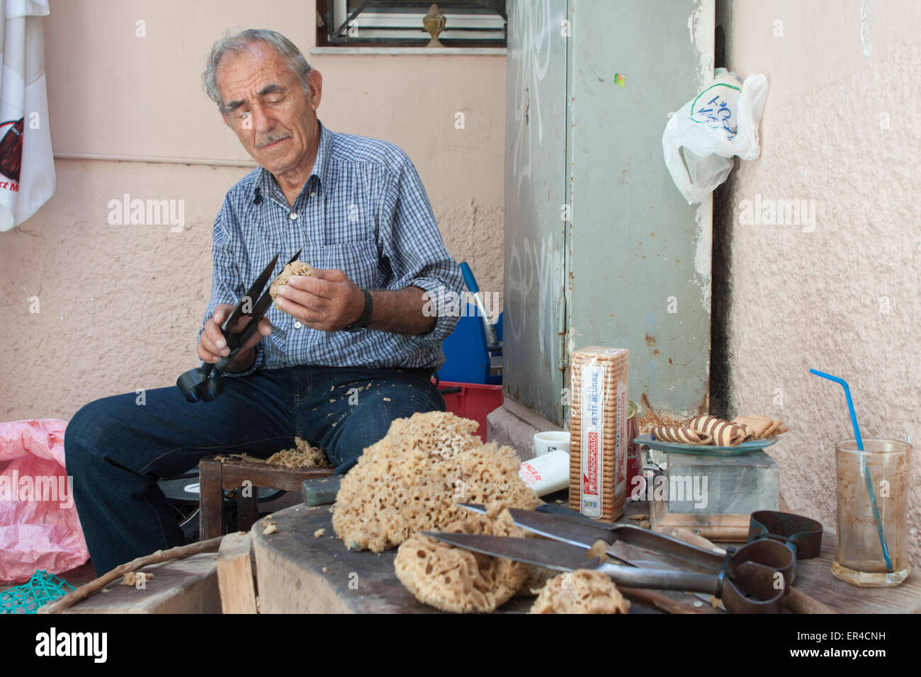 A man shaping natural spoinge in the traditional way on the Greek ...