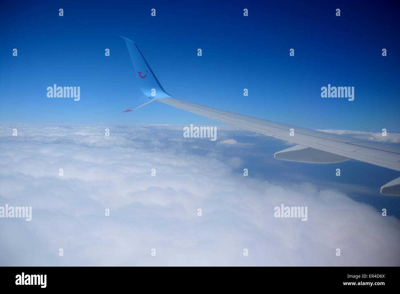 TUI aircraft wing flight above clouds with blue sky Stock Photo - Alamy