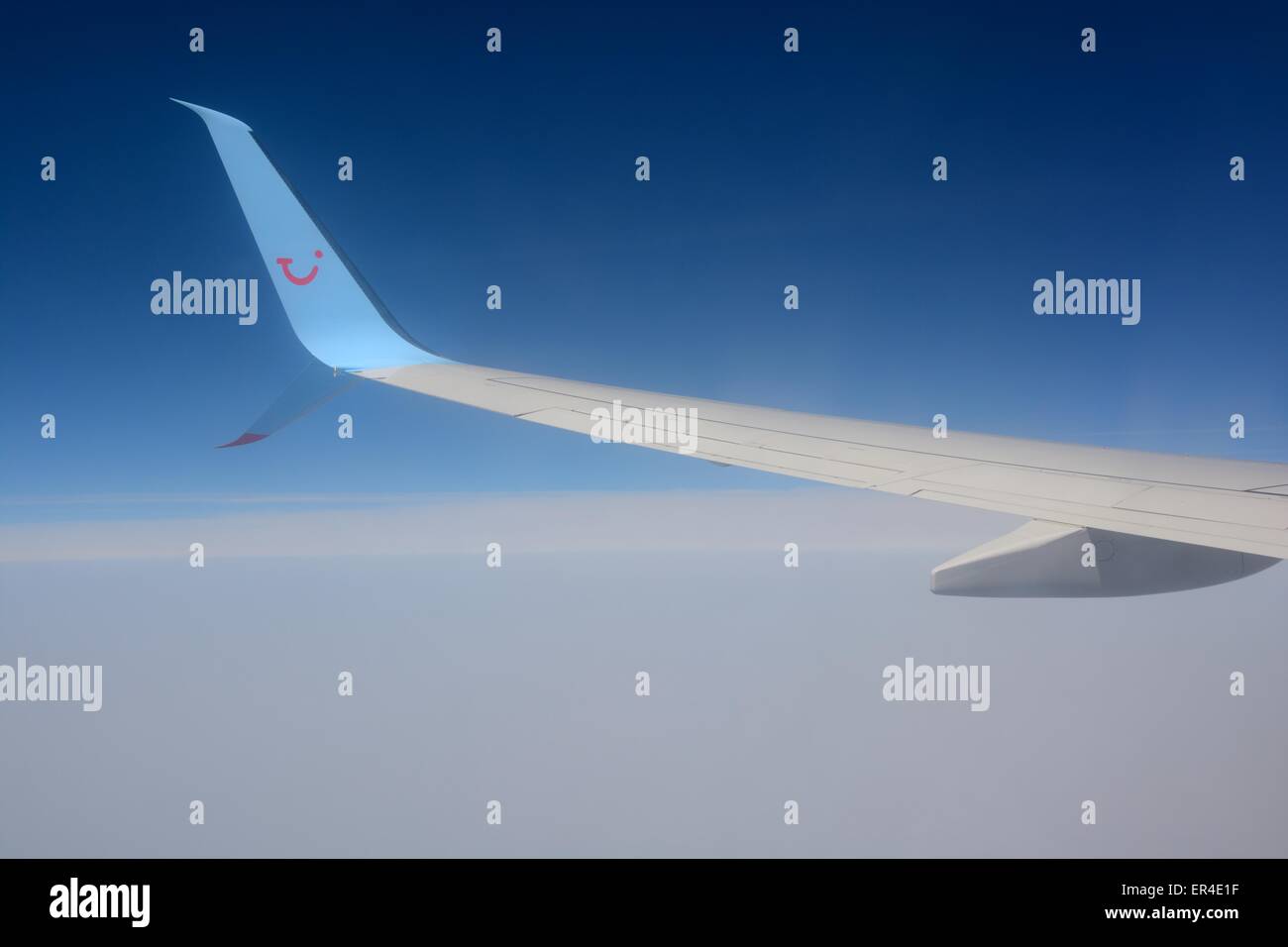 TUI aircraft wing flight above clouds with blue sky Stock Photo - Alamy