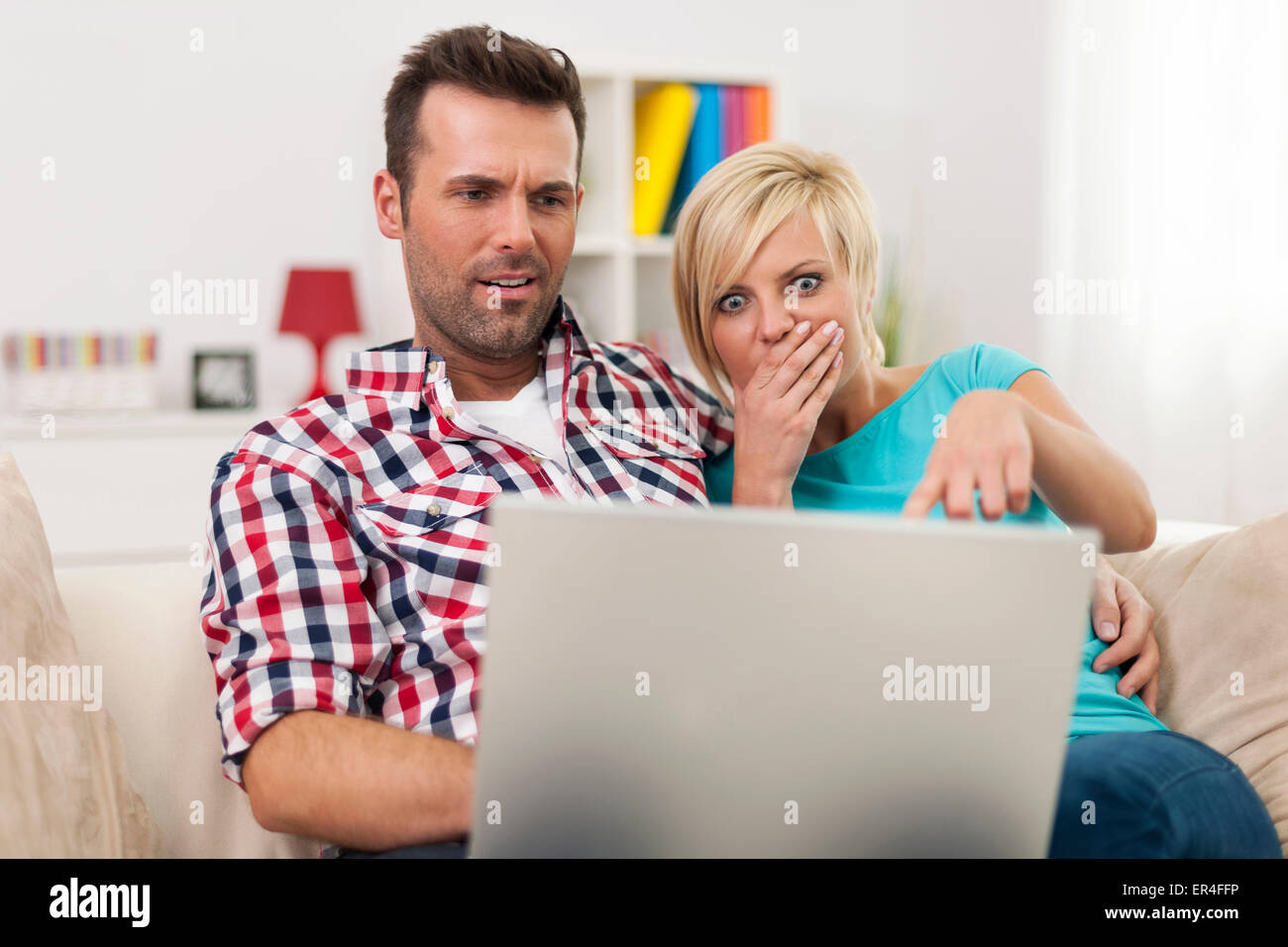 Young couple watching something on their laptop Stock Photo - Alamy