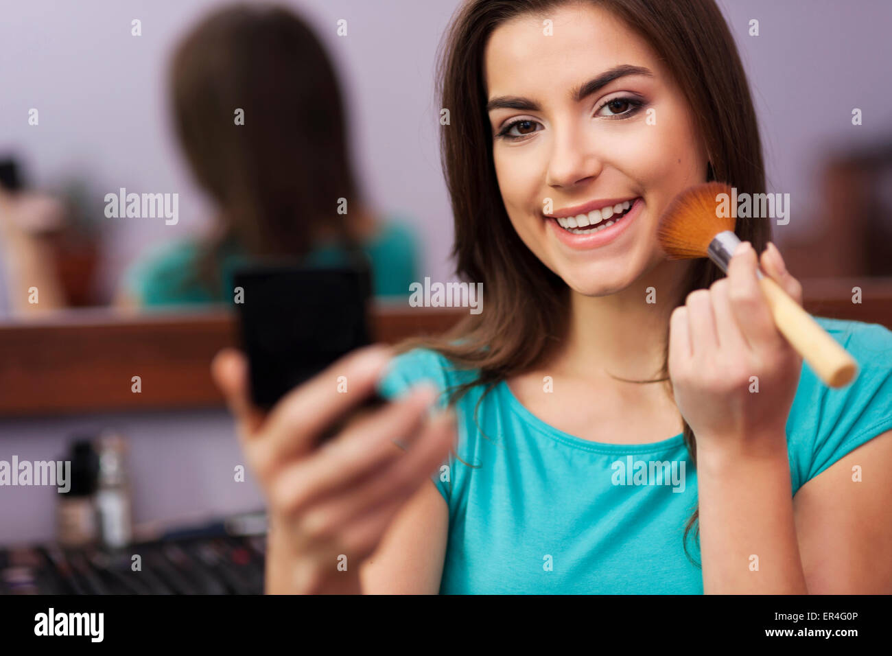 Pretty woman applying face powder debica hi-res stock photography and ...