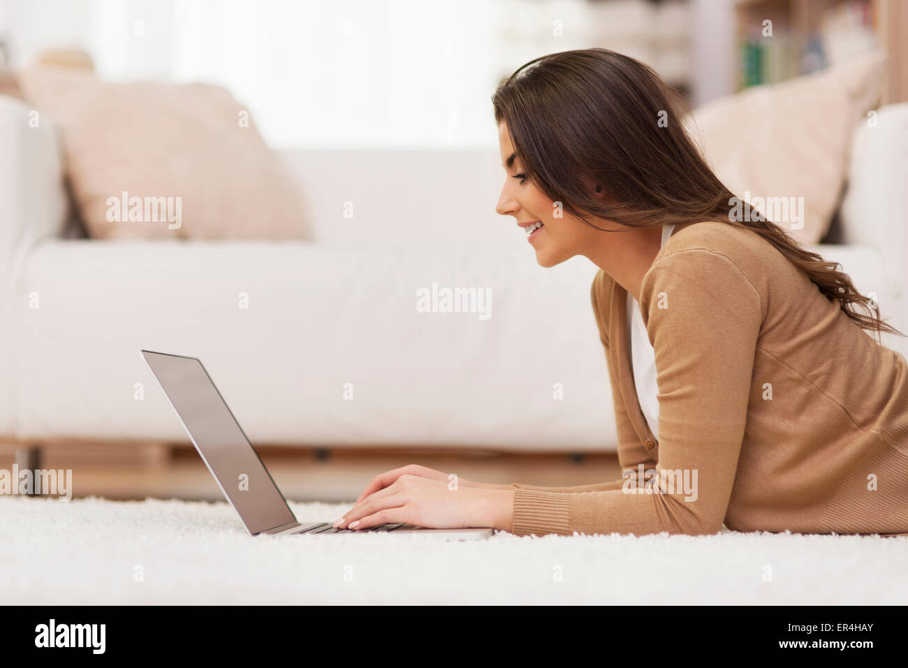 Beautiful woman relaxing with her laptop Stock Photo - Alamy