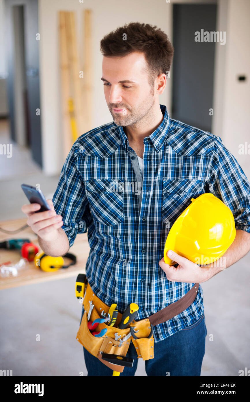 Construction worker using mobile phone during the working. Pilzno ...