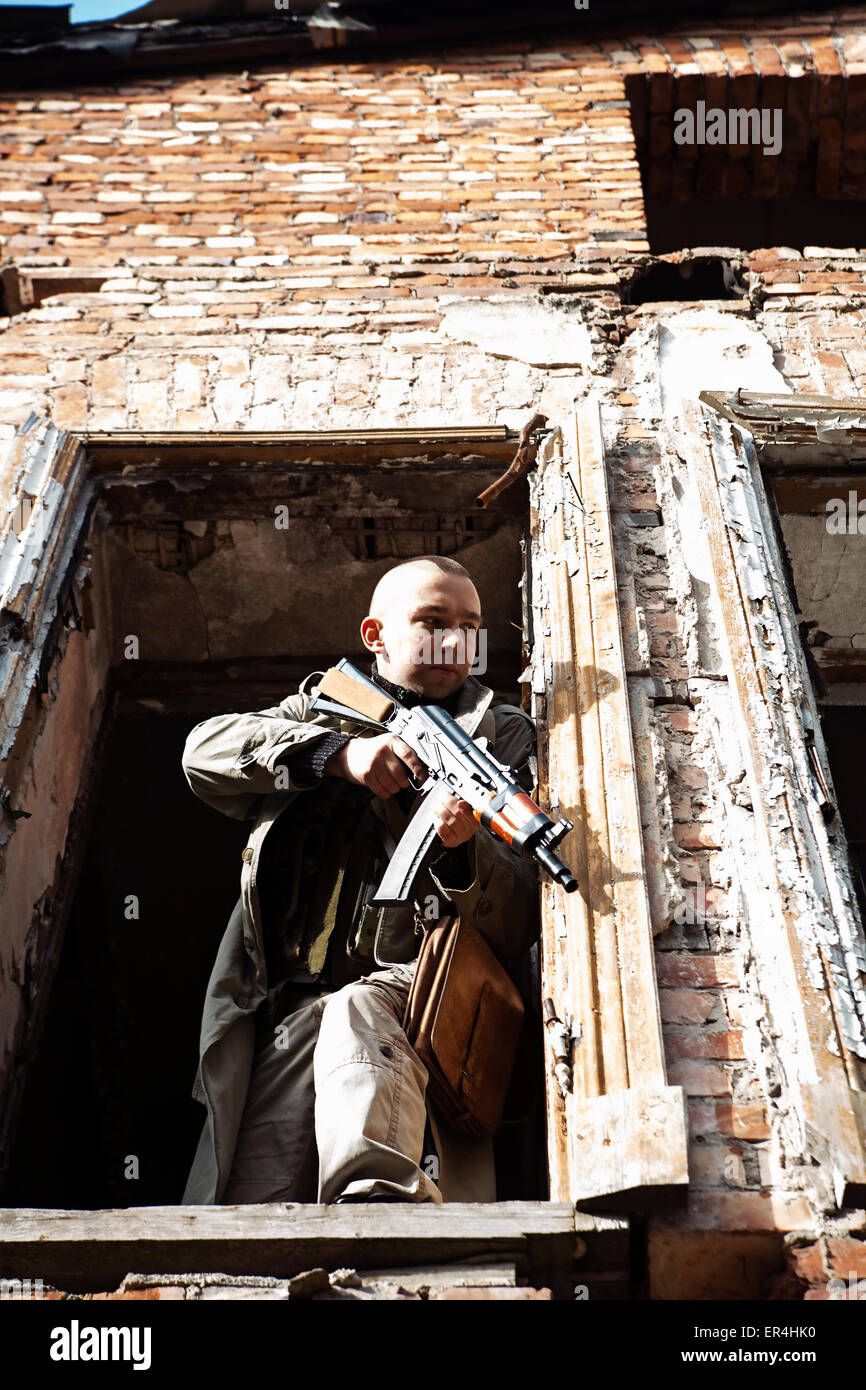Young man is aiming from the window Stock Photo - Alamy