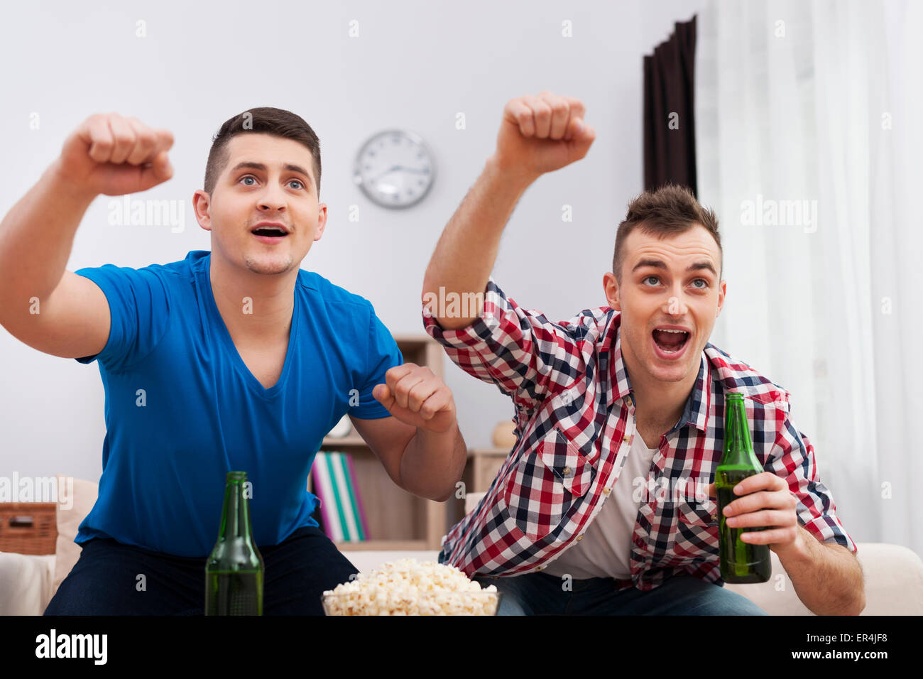 Friends watching football together Stock Photo - Alamy