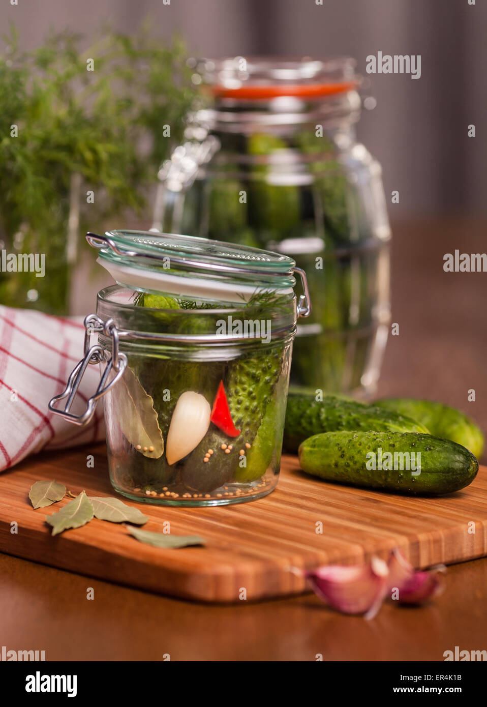 Pickles with garlic in glass jar on cutting board. Debica, Poland Stock ...
