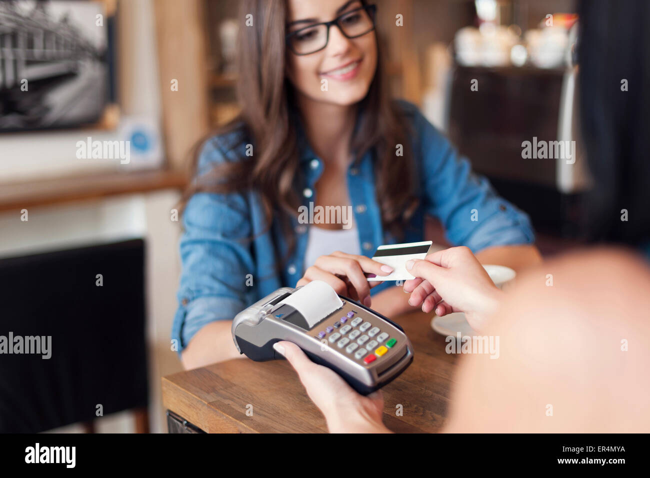 Smiling woman paying for coffee by credit card. Krakow, Poland Stock ...