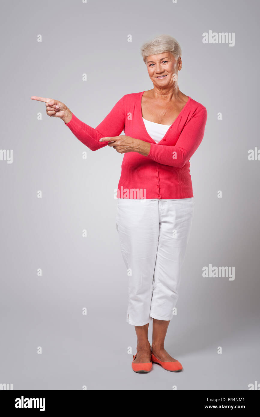 Older lady pointing to caption space Stock Photo - Alamy