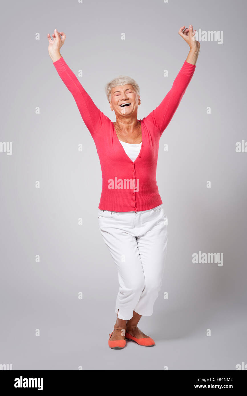Older lady throwing up her arms in joy Stock Photo - Alamy