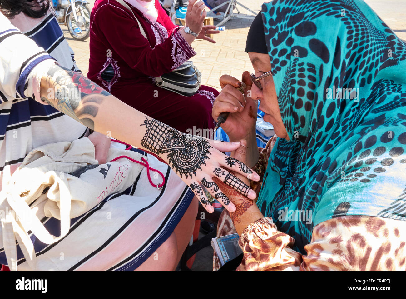 Lady creating a henna tattoo at 'Djeema el fnaa' - Marrakech market ...