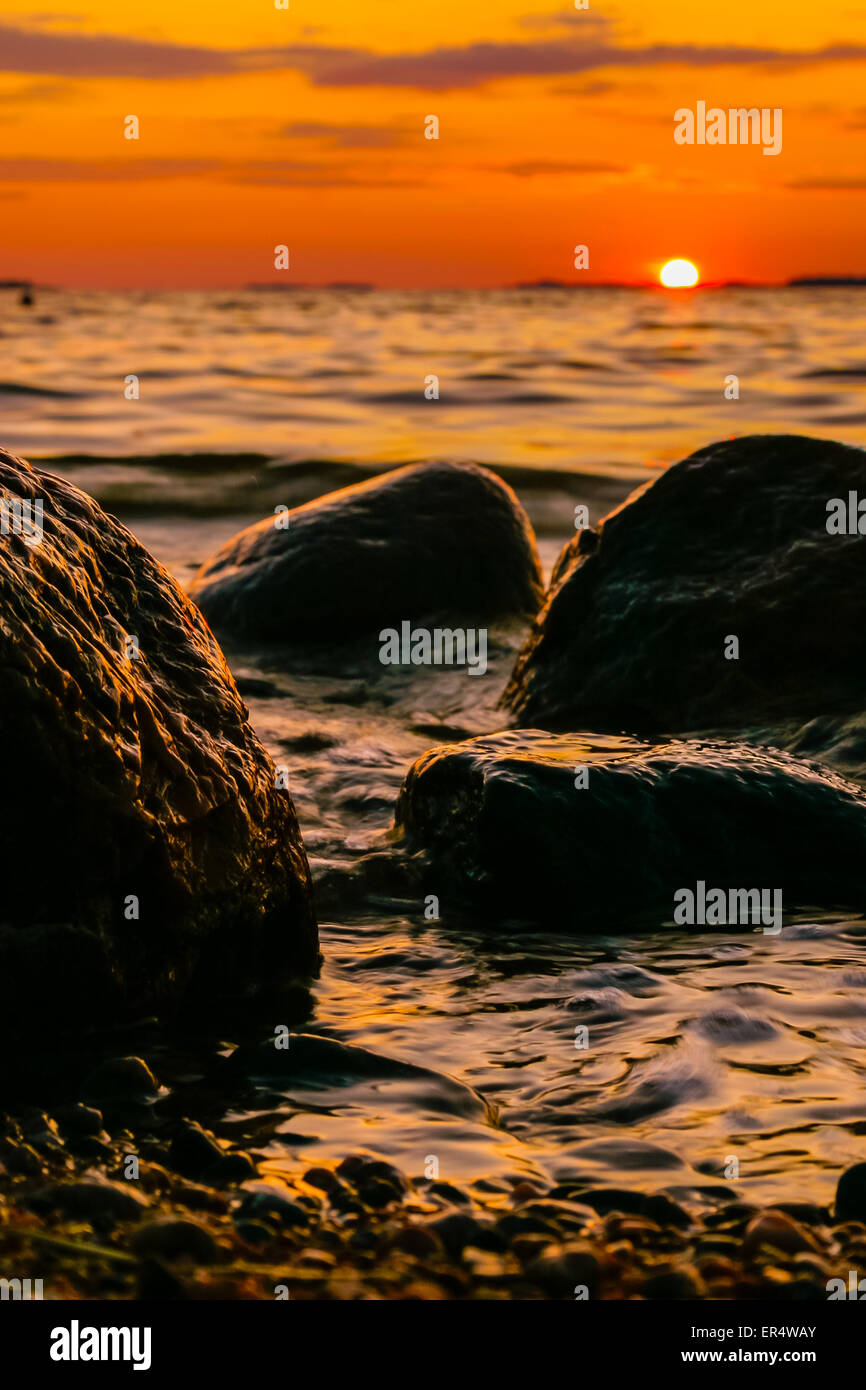 Sunset landscape with water waves and rocks Stock Photo - Alamy